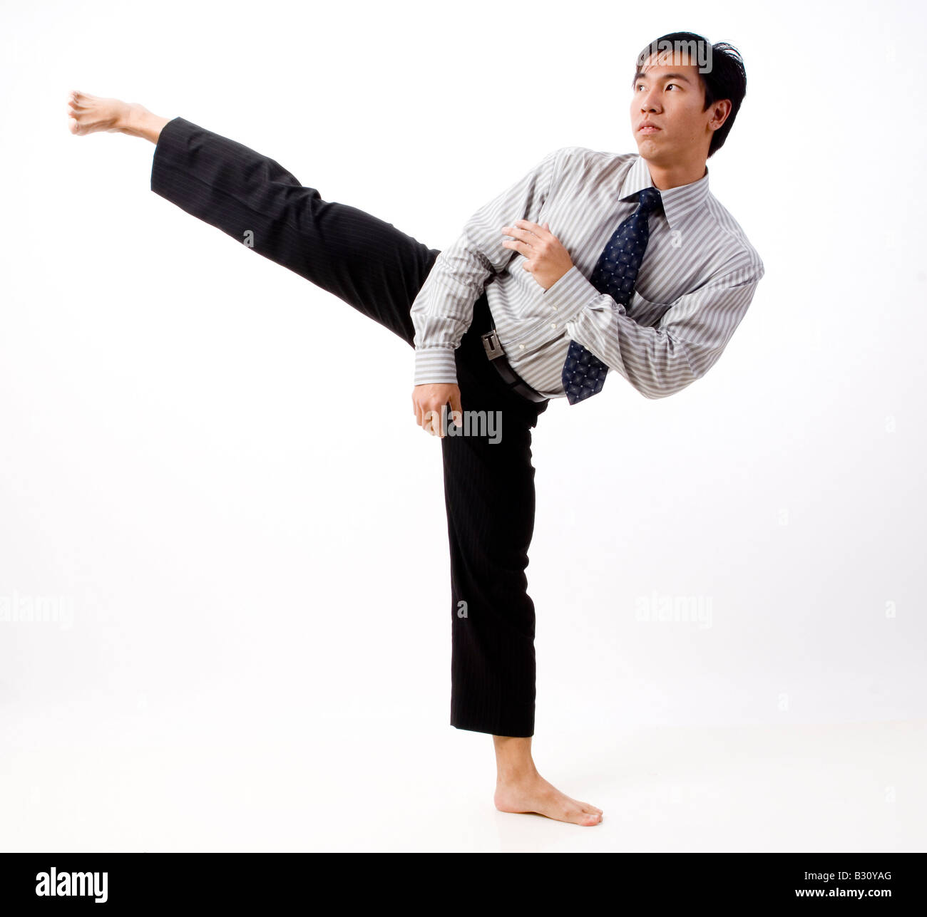 A young asian businessman does a high karate kick Stock Photo - Alamy