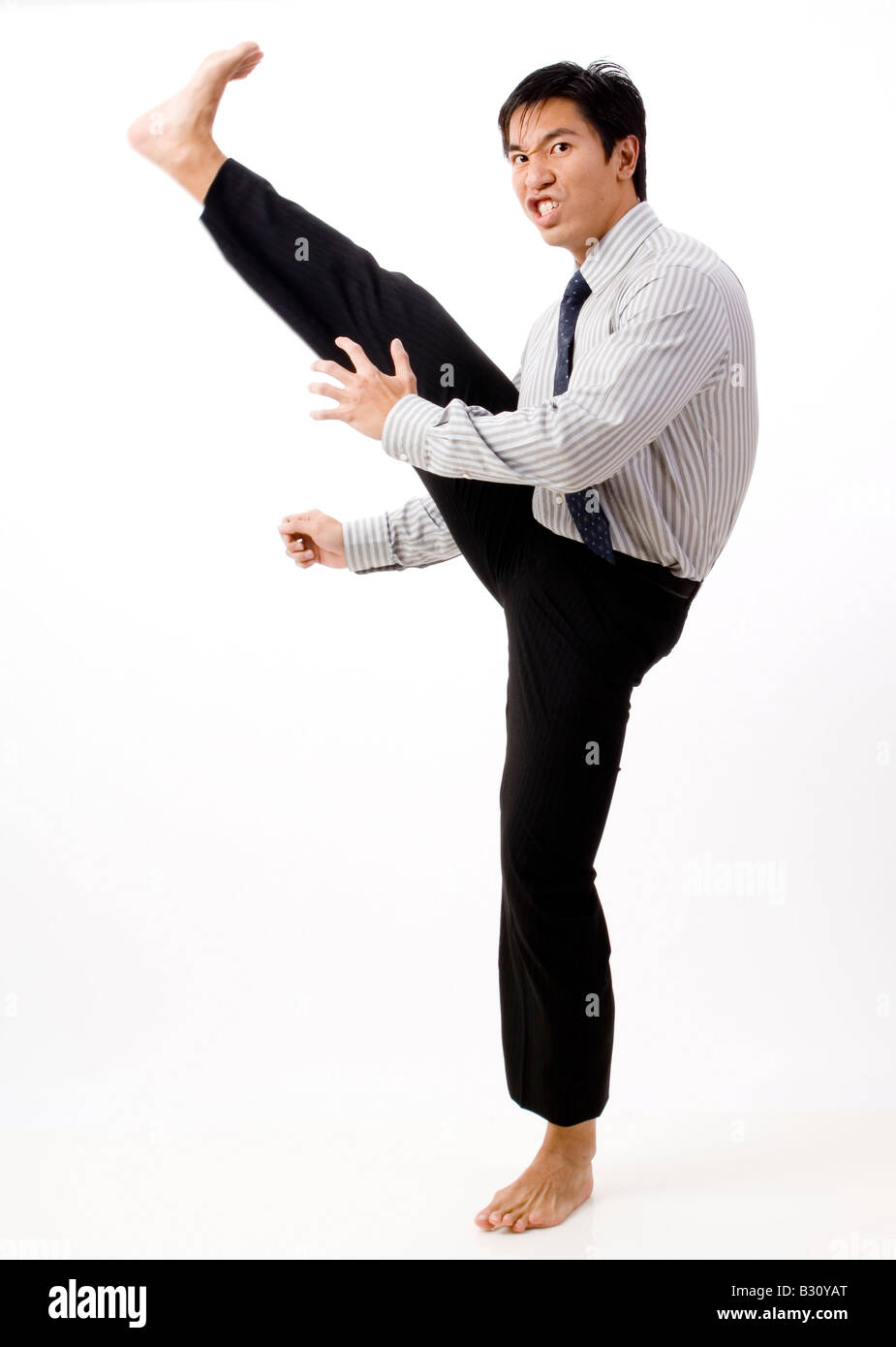 A young asian businessman looks tough doing a karate kick Stock Photo ...