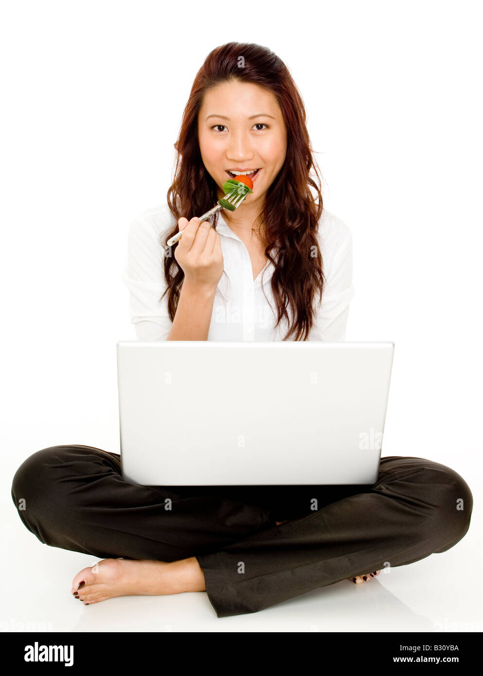 A pretty young asian woman eating salad with laptop on lap Stock Photo ...