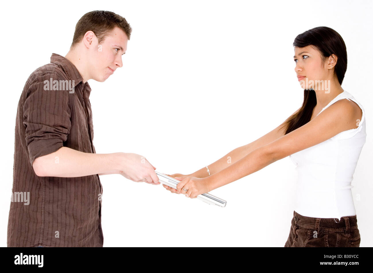 A young man and woman fight over a laptop Stock Photo - Alamy