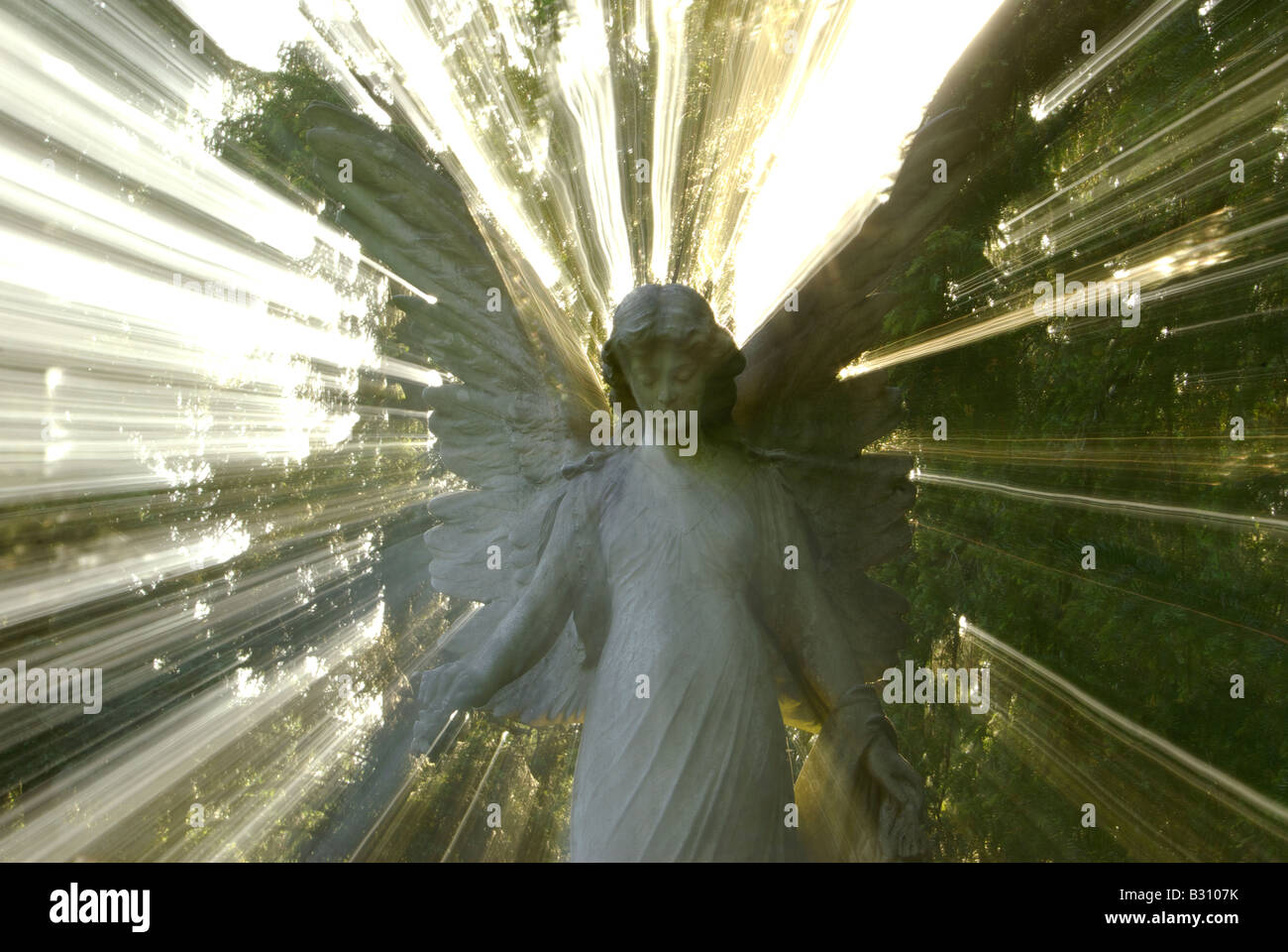 standing angel sculpture surrounded by a dazzling aura of light Stock ...