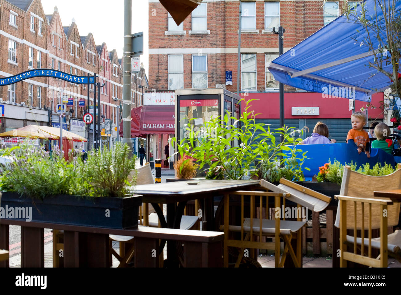 from a cafe children and parents sit and enjoy the scene in Balham ...