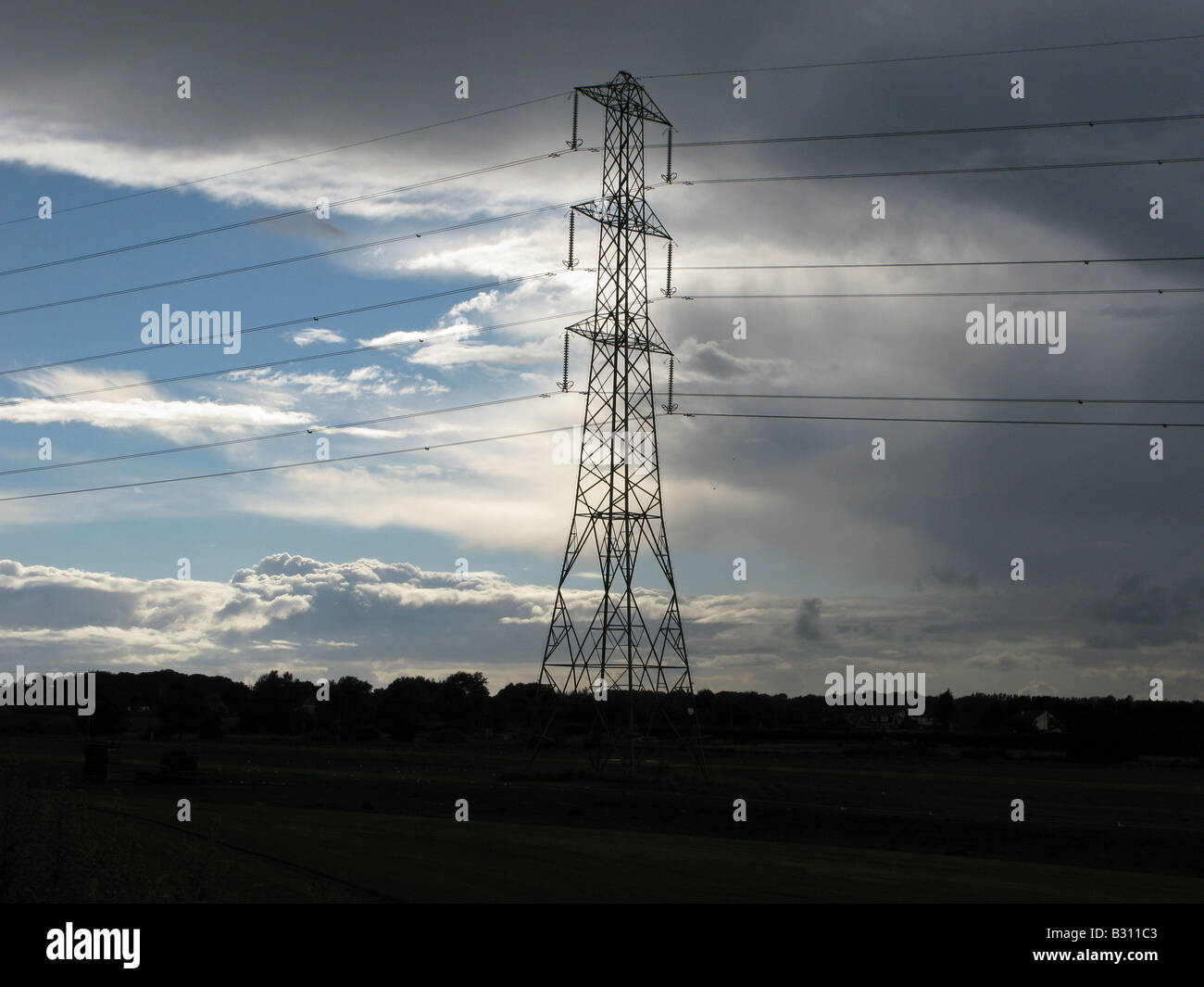 Electricity pylon with storm clouds and blue sky background Stock Photo ...