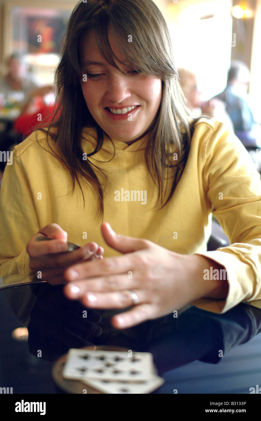 Young woman playing cards at table Stock Photo - Alamy