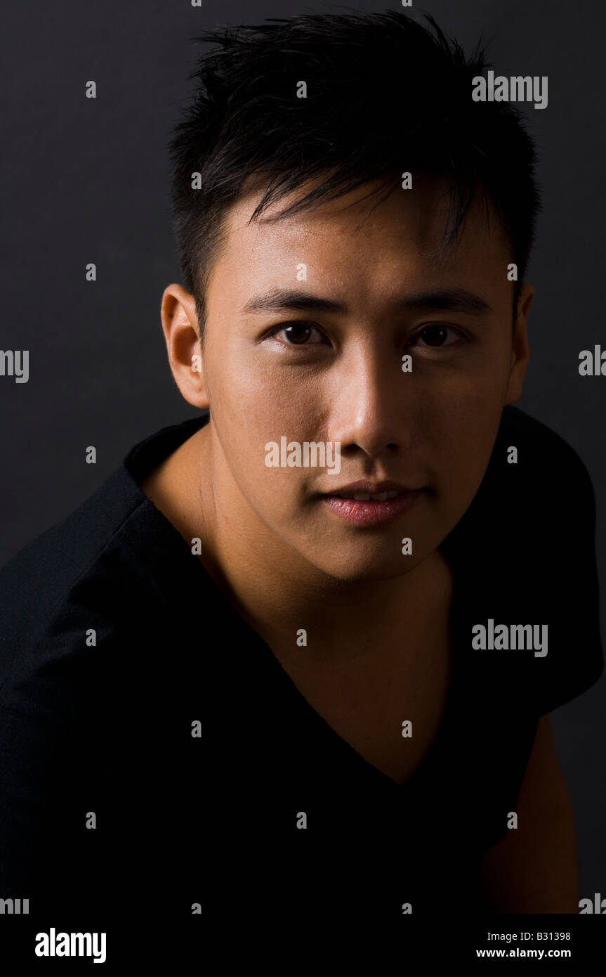 A smiling male chinese model in black Stock Photo - Alamy
