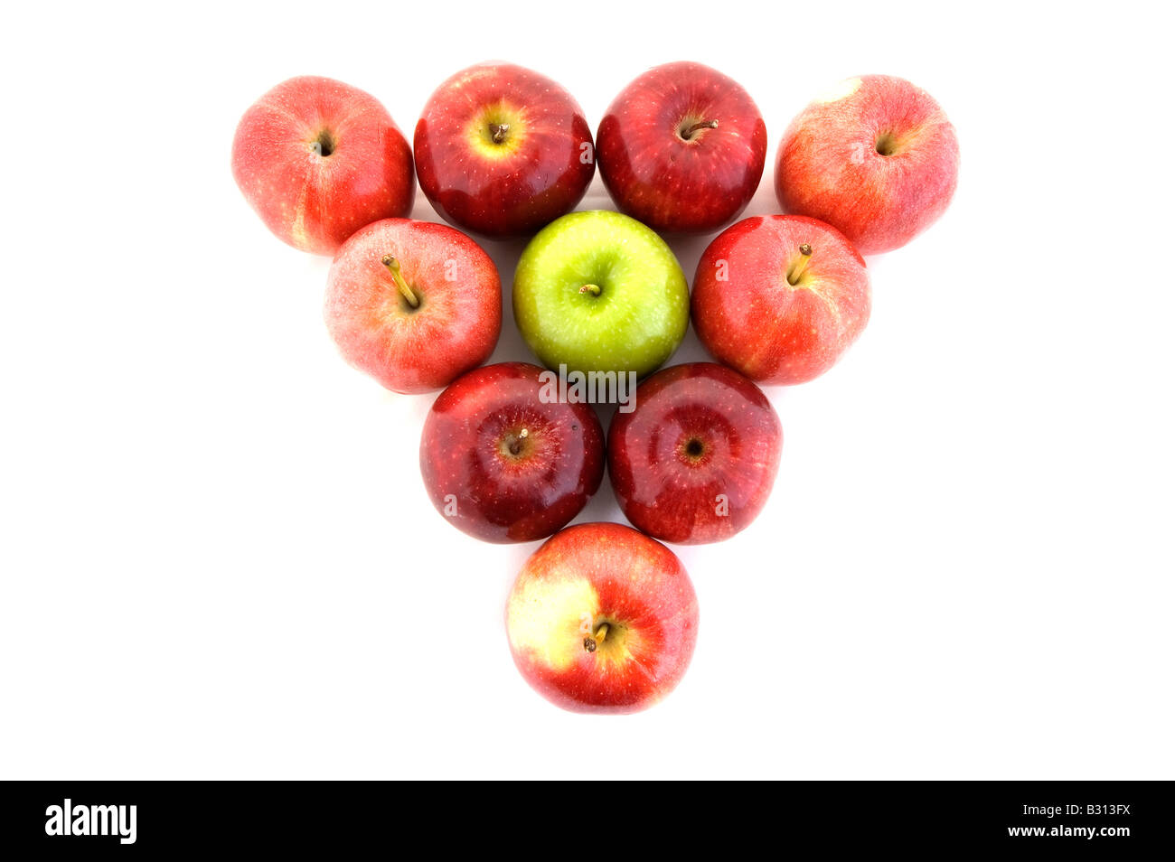 A green apple in a triangle of red apples Stock Photo - Alamy