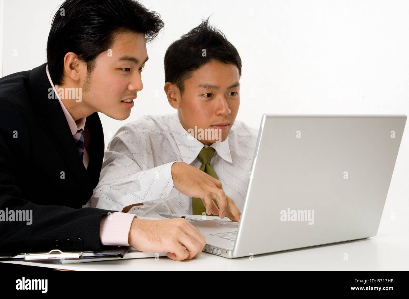 Two young asian men working on a laptop computer Stock Photo - Alamy