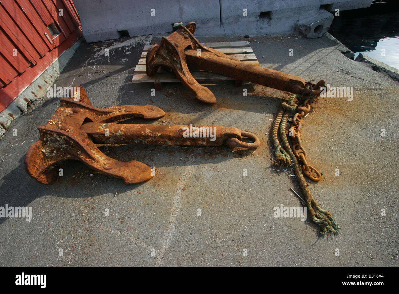 OId rusted, pair of anchors dumped on the docks in a small port in ...