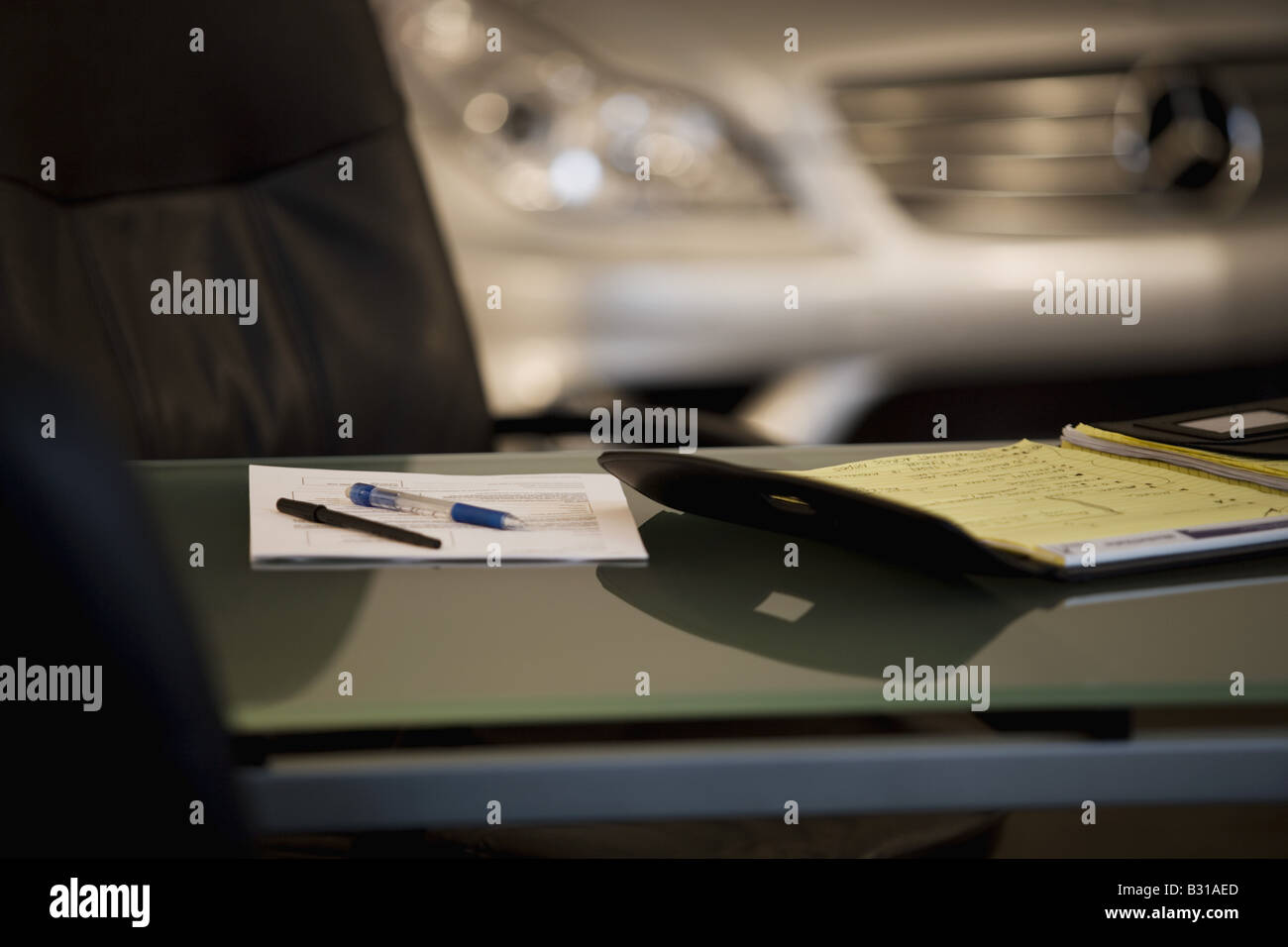 Empty desk with dealership paperwork Stock Photo - Alamy