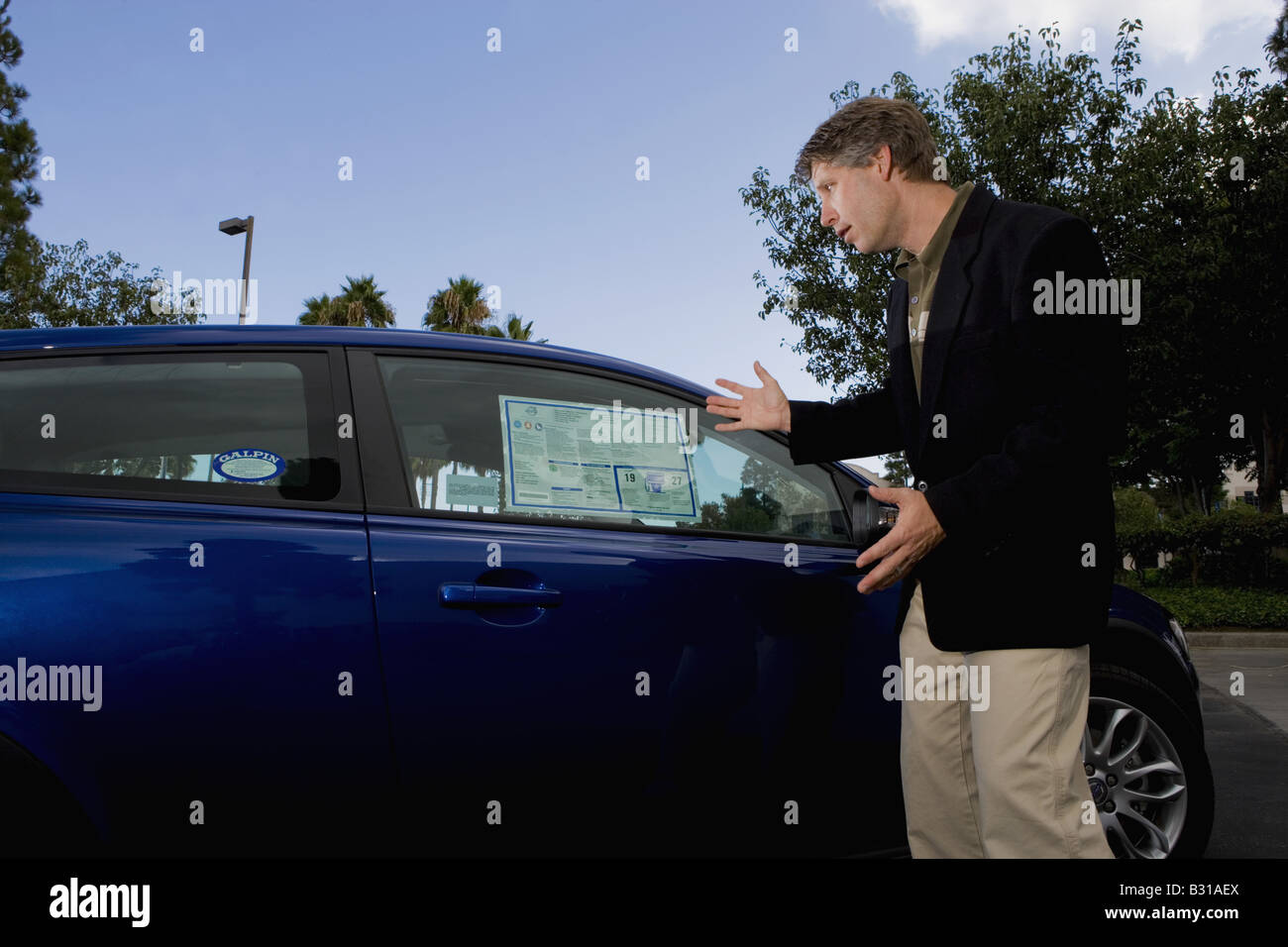 Enthusiastic car salesman with new car Stock Photo - Alamy
