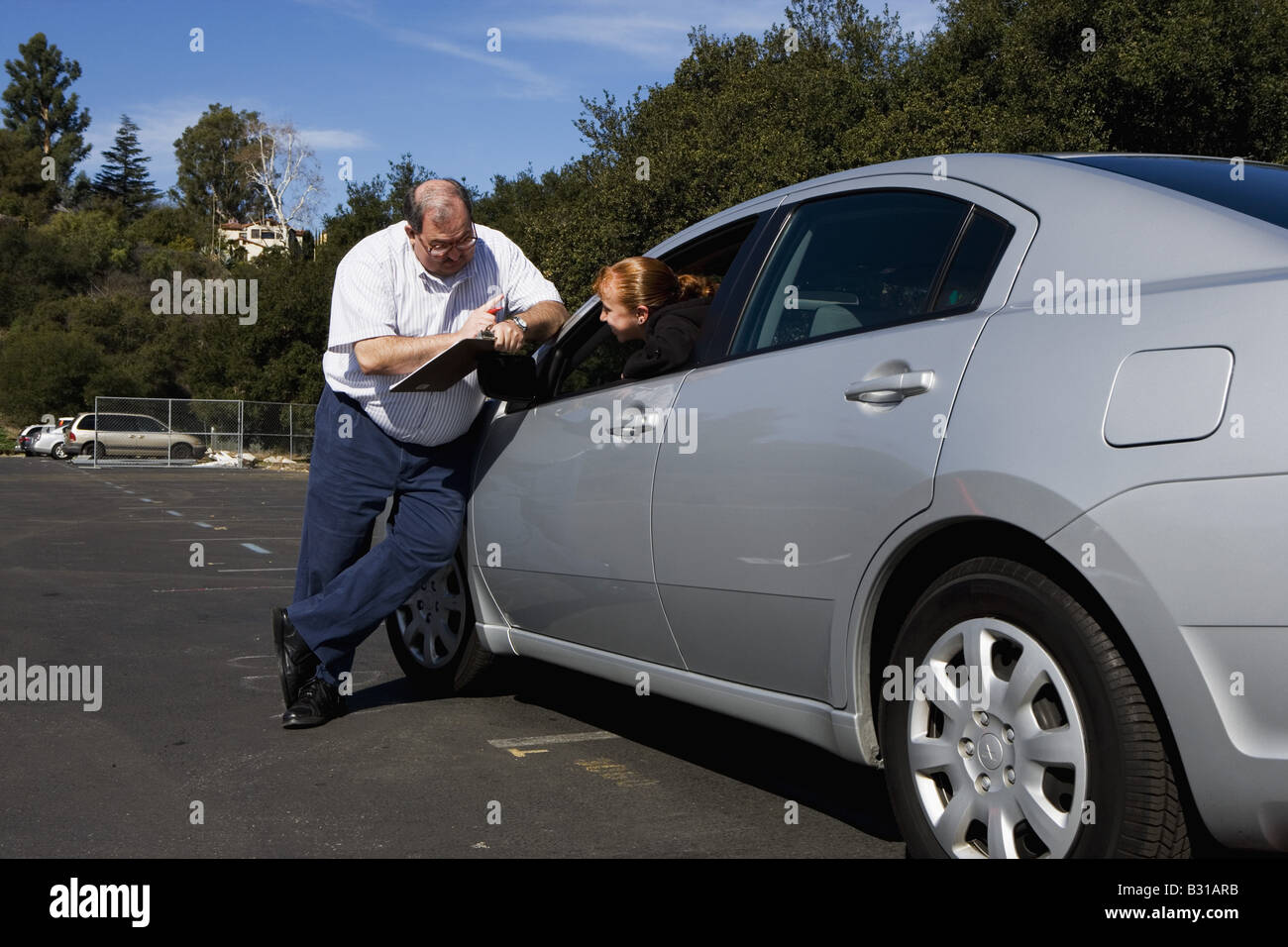 Driving instructor talking with teen driver Stock Photo - Alamy