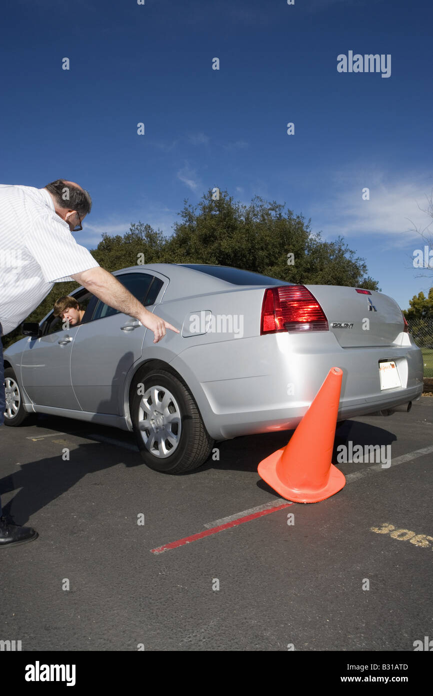 Driving instructor pointing to cone being knocked over by teen driver ...