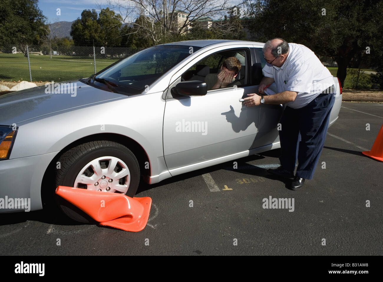 Driving instructor points out crushed cone to teen driver Stock Photo ...