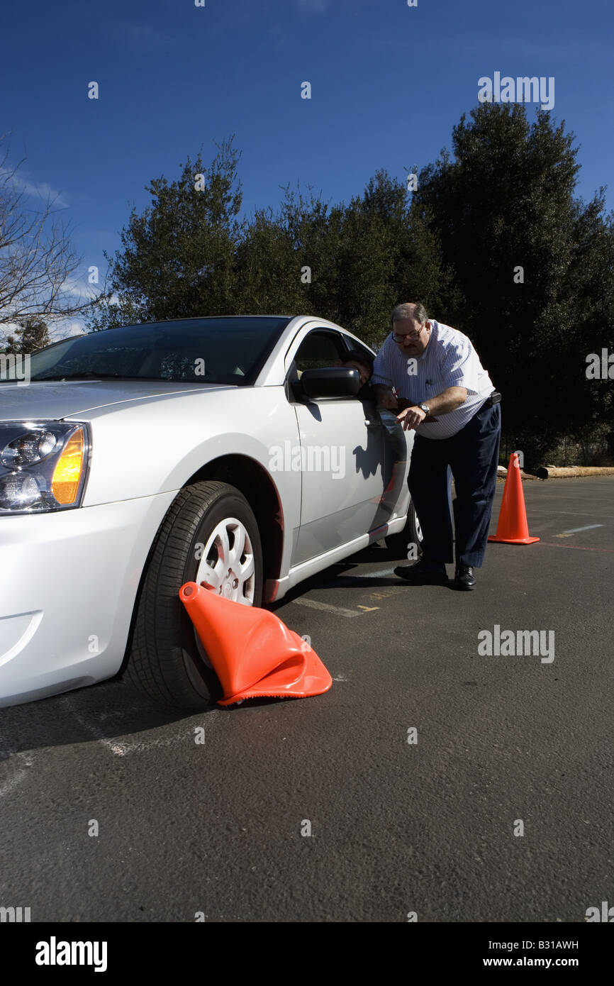 Driving instructor points out crushed cone to teen driver Stock Photo ...