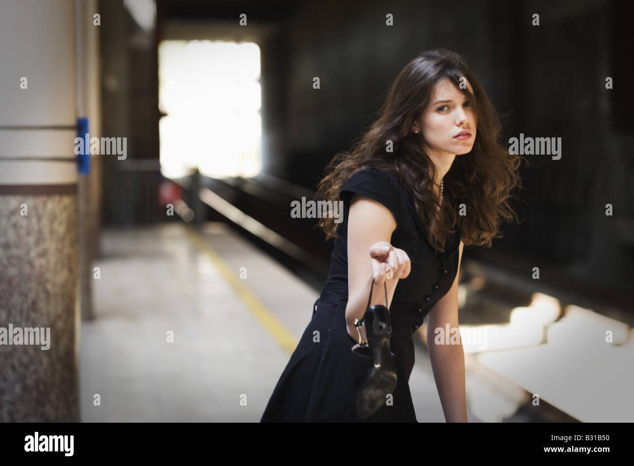 Young woman on train platform with broken shoe Stock Photo - Alamy