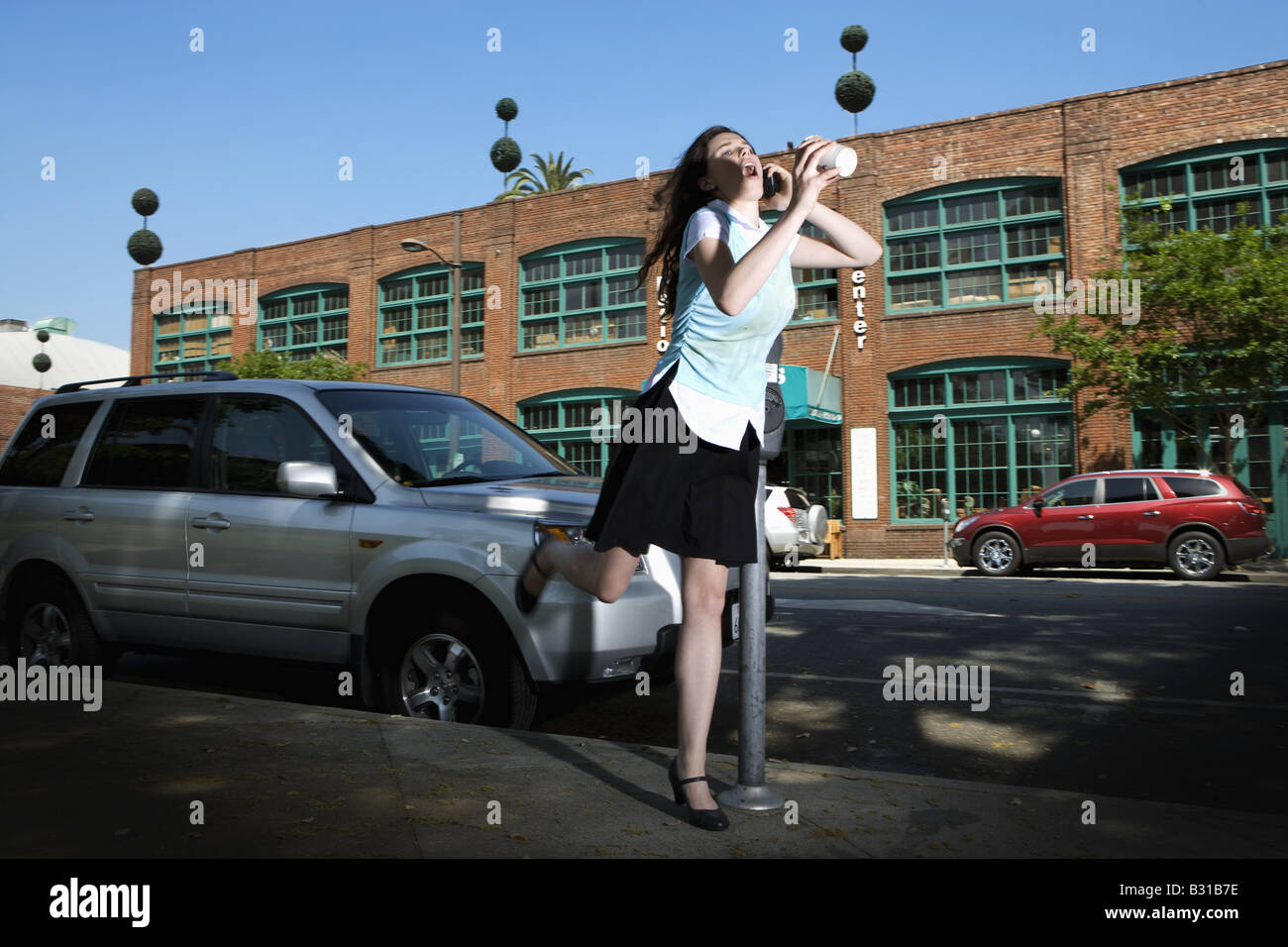 Young woman tripping up with cup of coffee Stock Photo - Alamy