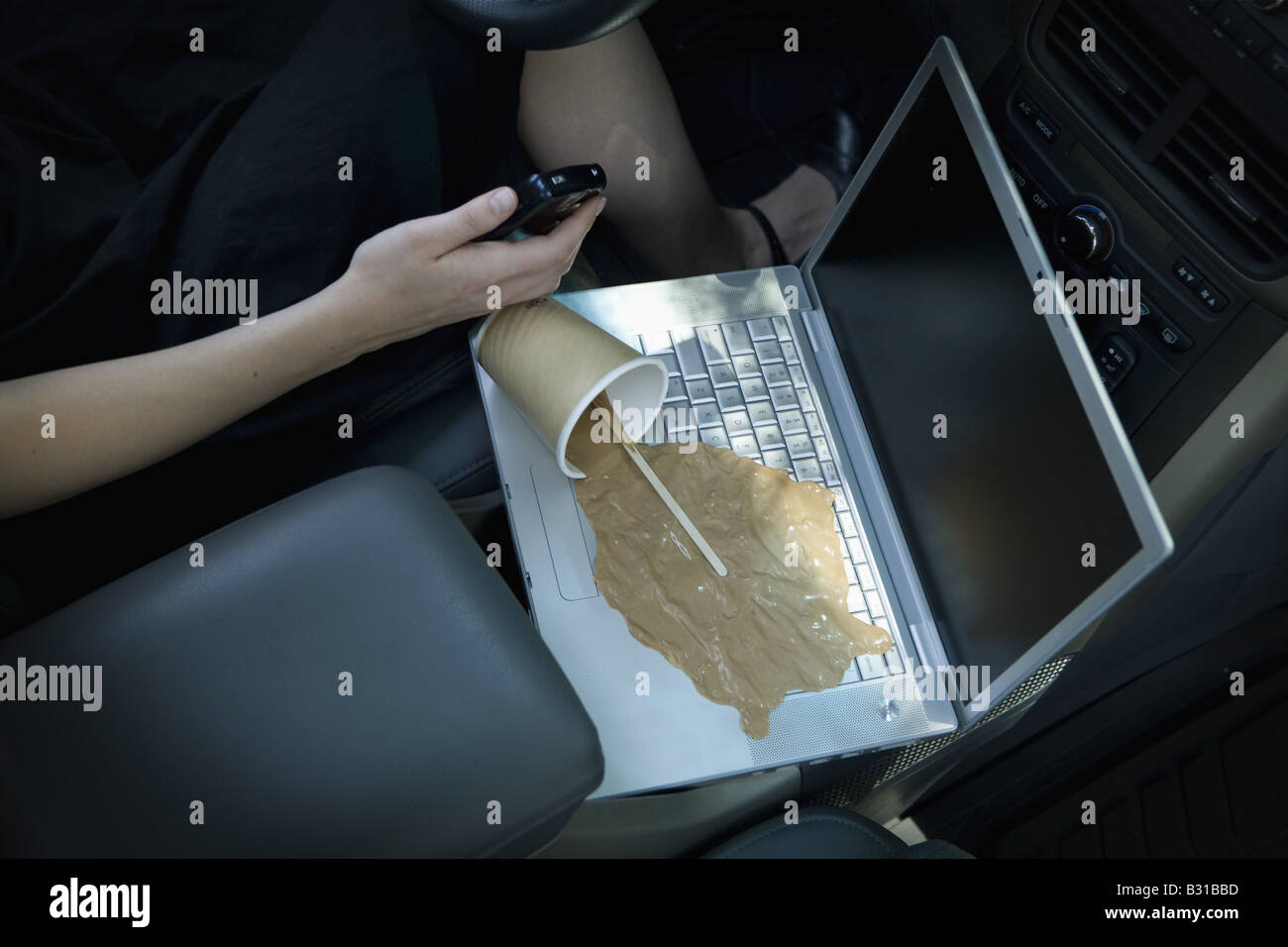 Young woman knocking over cup of coffee onto laptop Stock Photo - Alamy