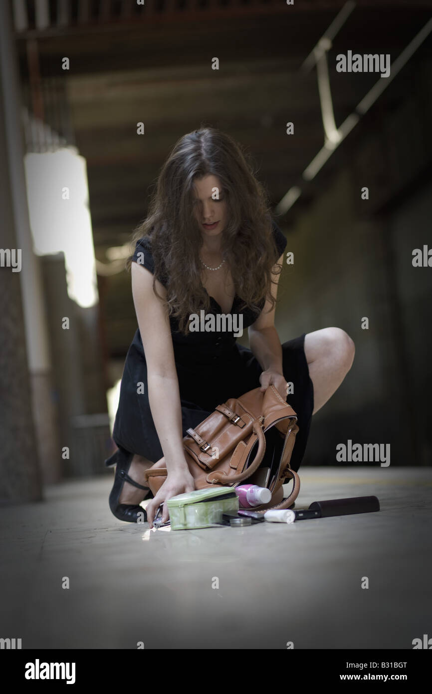 Young woman picking up spilled personal items from the floor Stock ...