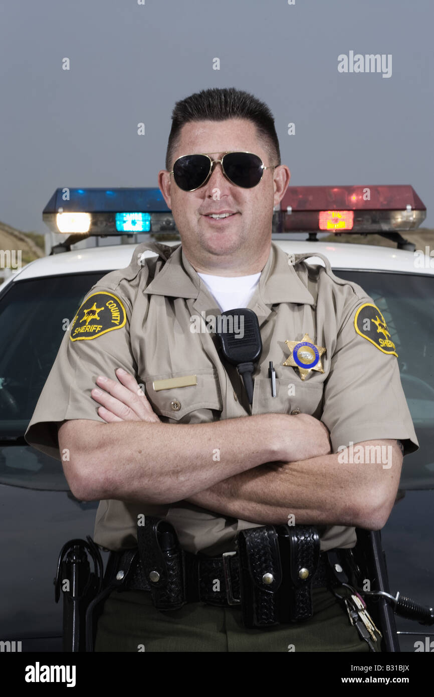 Police officer standing in front of police car Stock Photo - Alamy