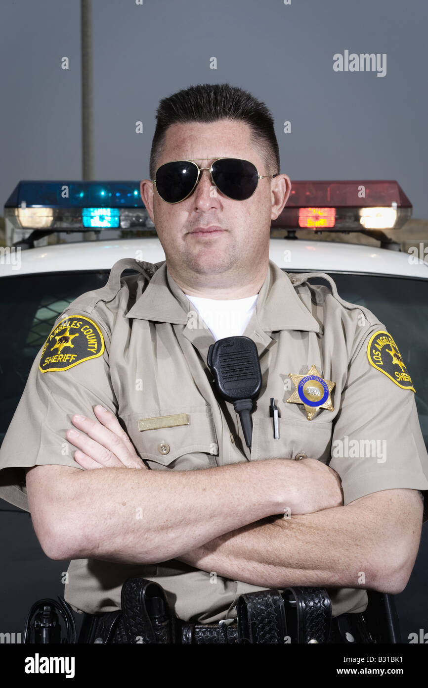 Police officer standing in front of police car Stock Photo - Alamy