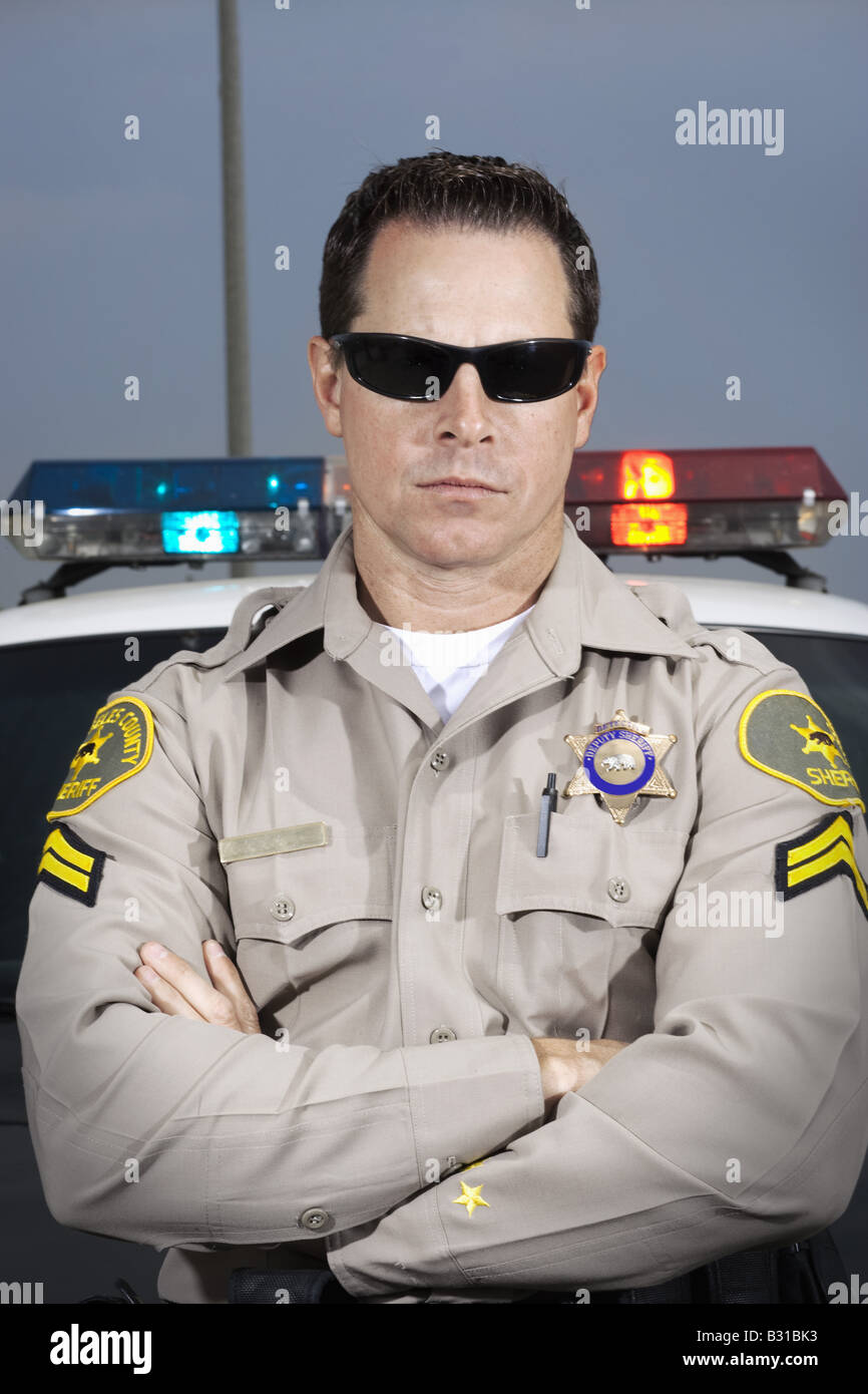 Police officer standing in front of police car Stock Photo - Alamy