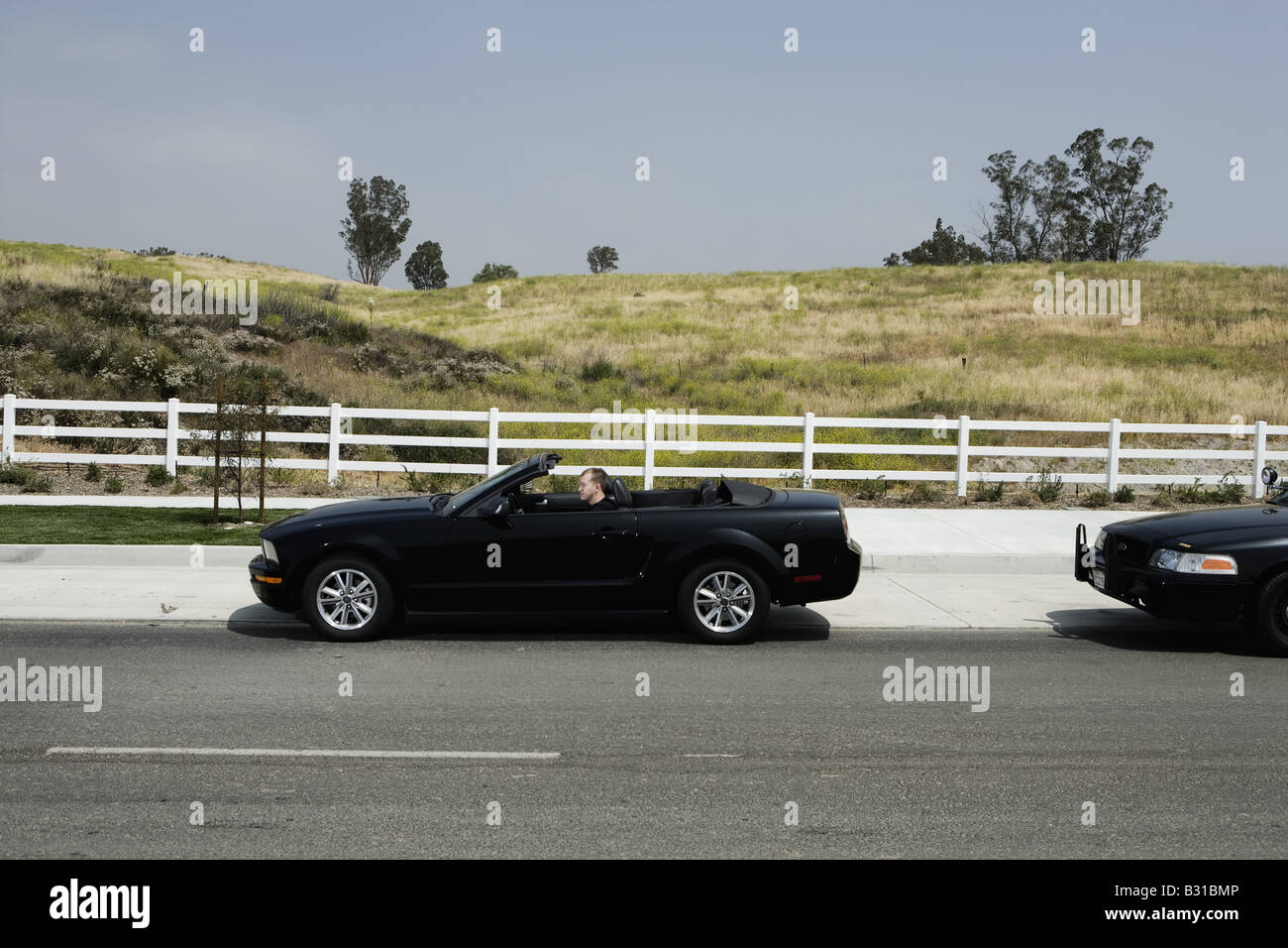 Police car stopped behind man in Mustang Stock Photo - Alamy