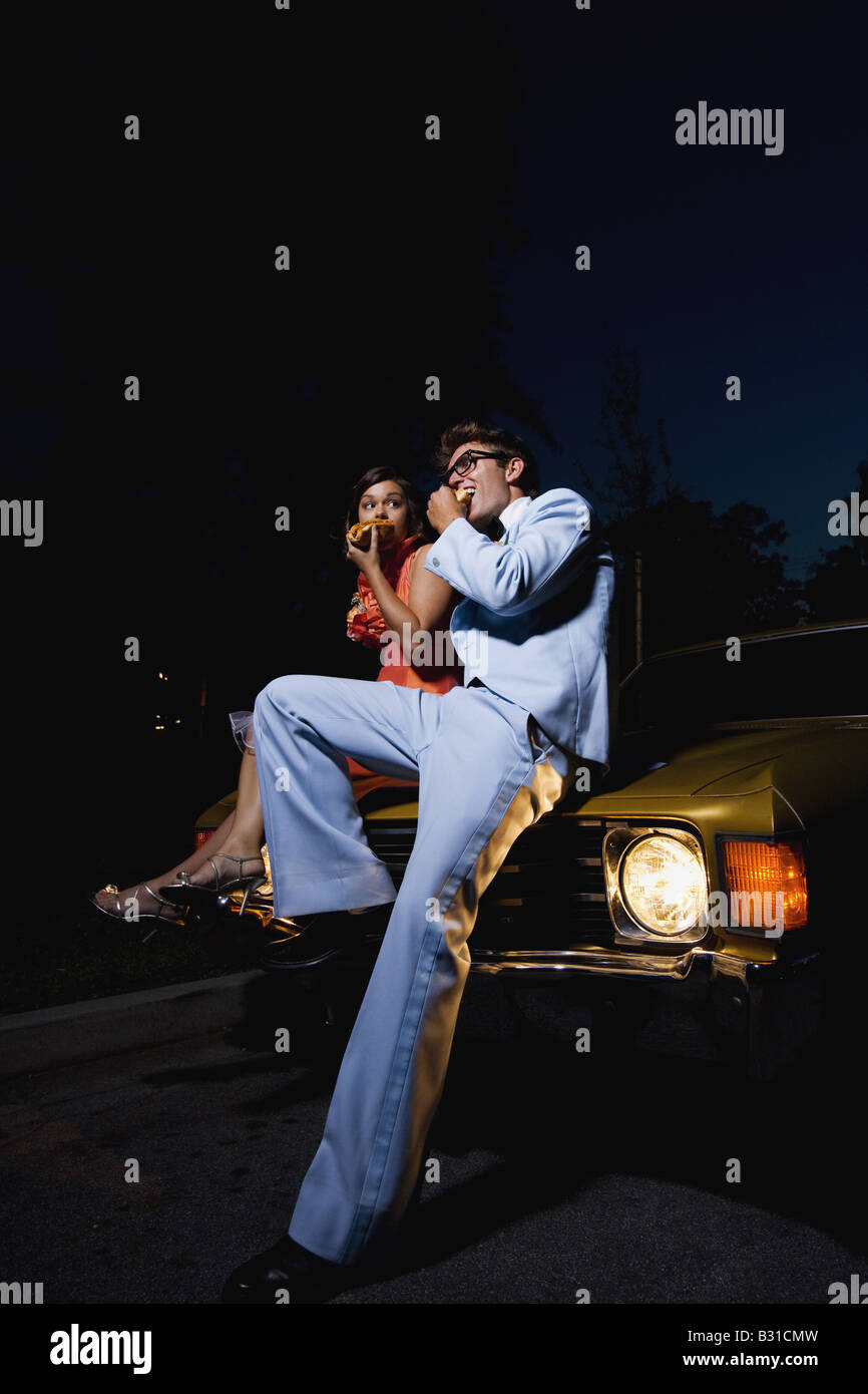 Prom goers sitting on car eating hot dogs Stock Photo - Alamy