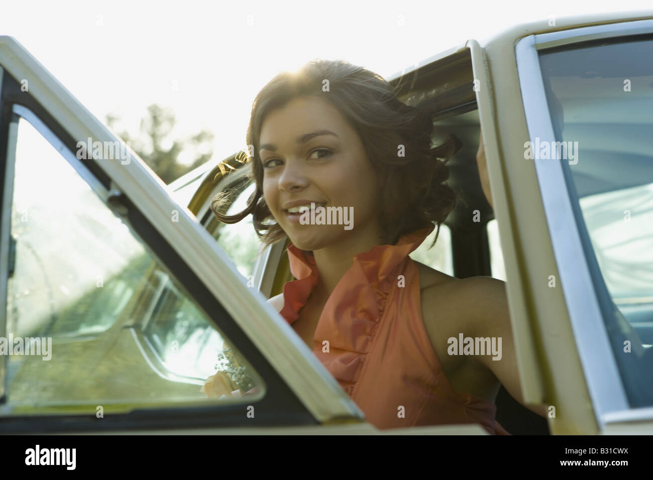 Young woman getting out of car Stock Photo - Alamy