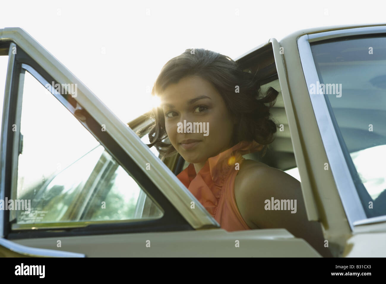 Young woman getting out of car Stock Photo - Alamy