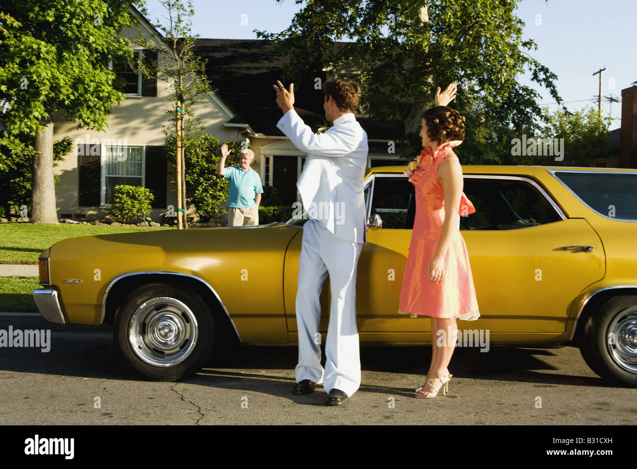 Prom goers waving goodbye to father Stock Photo - Alamy