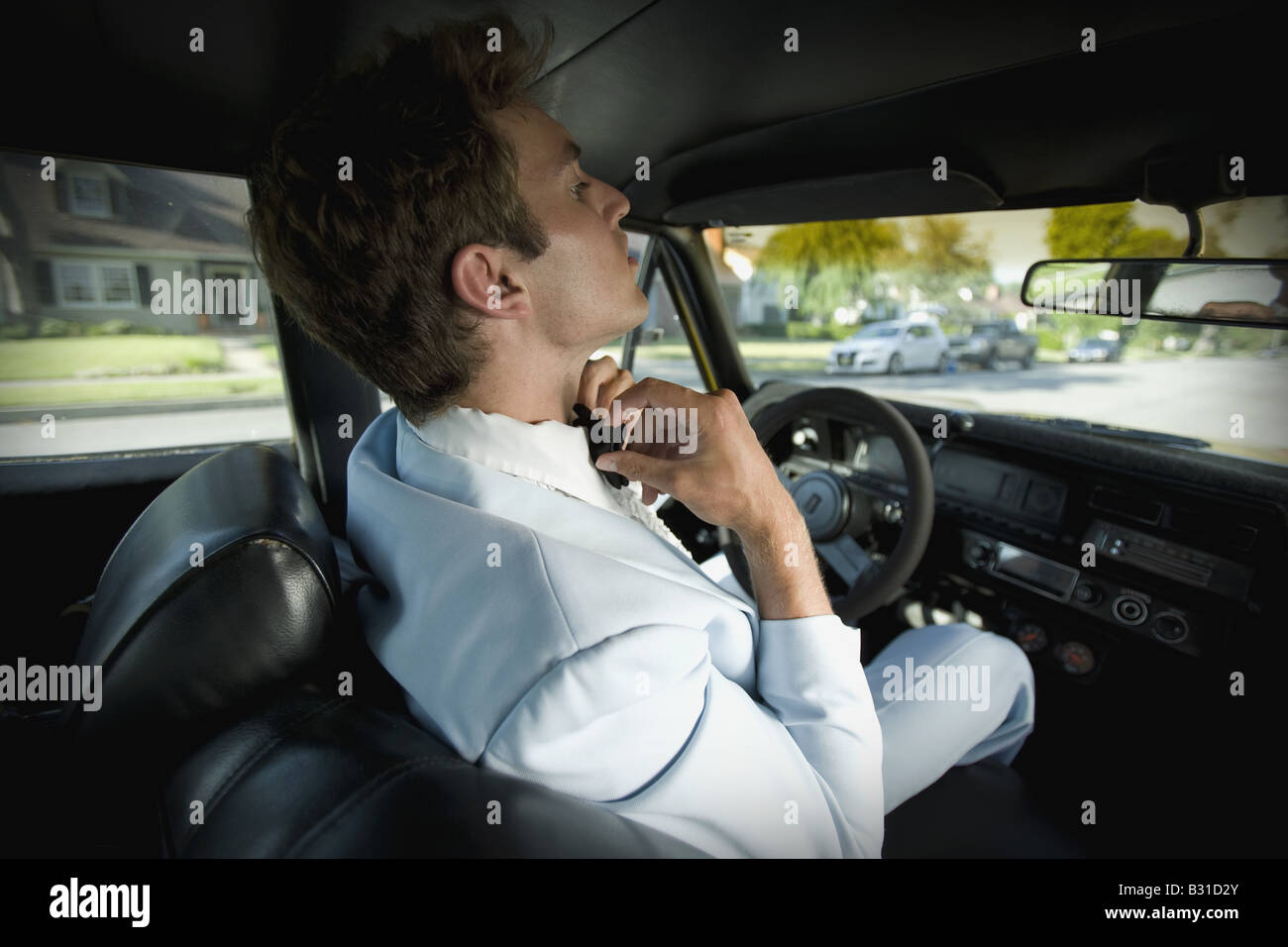 Young man checking bow tie in car mirror Stock Photo - Alamy