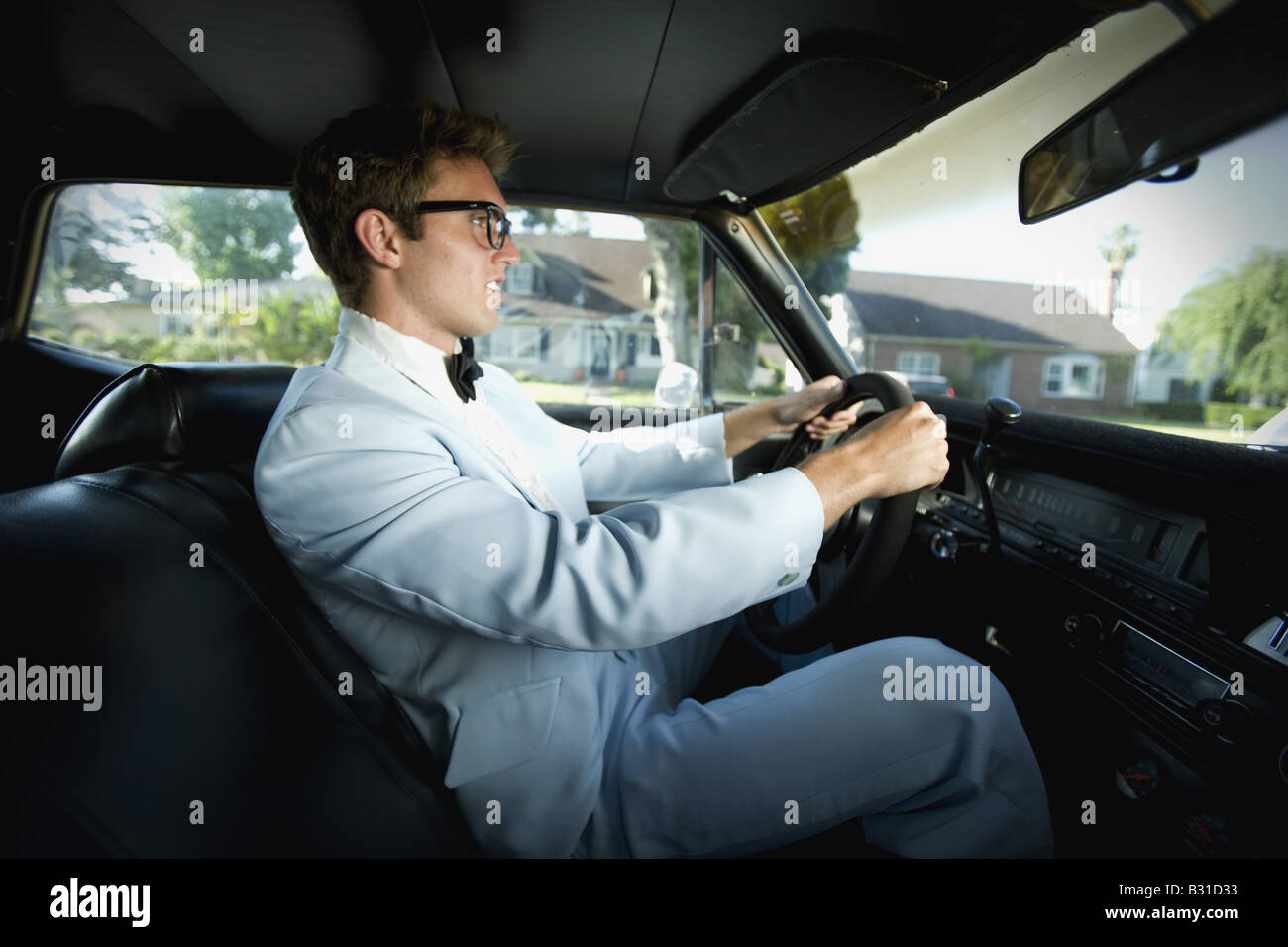 Young man driving in car to prom Stock Photo - Alamy