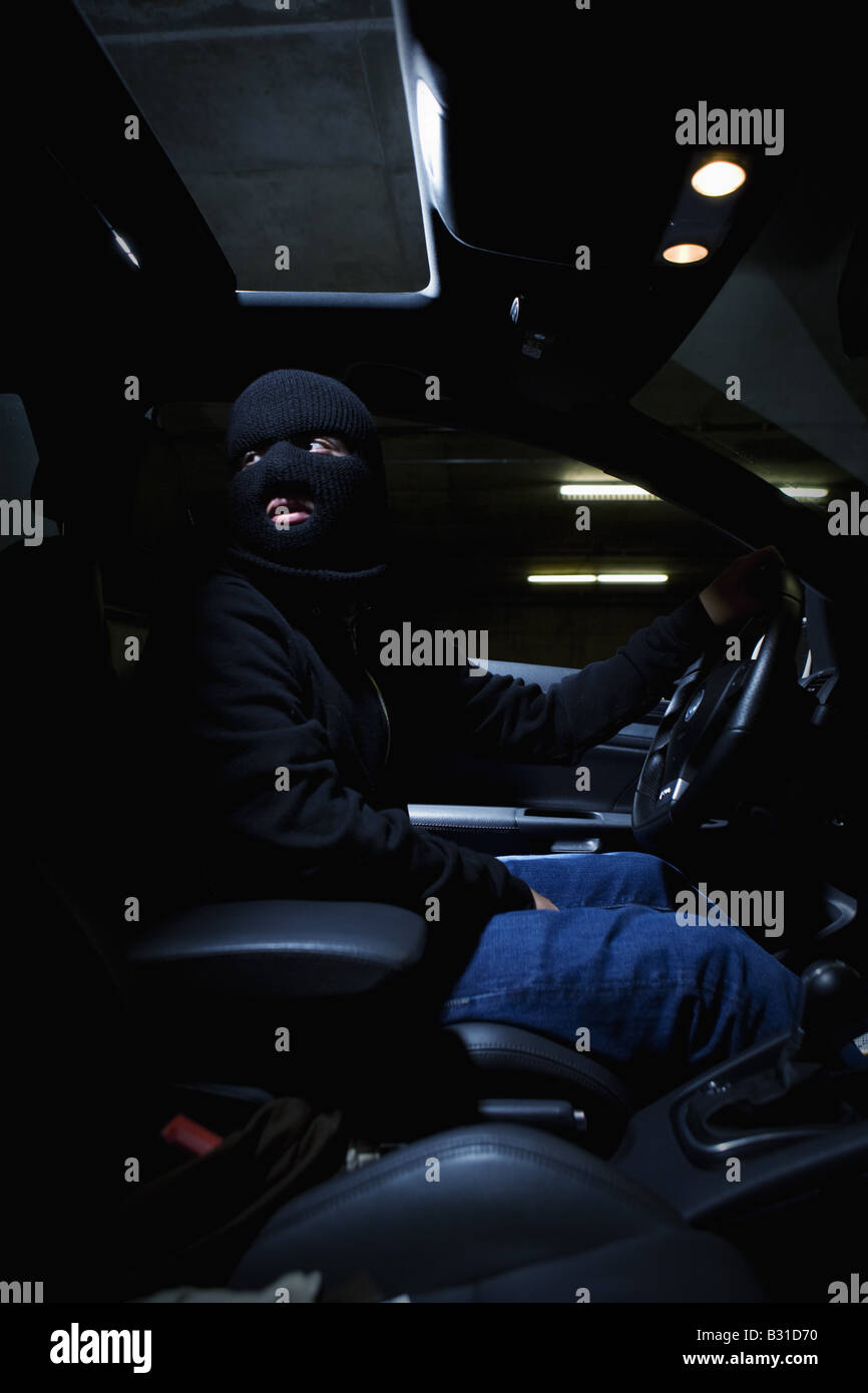 Masked thief sitting in car Stock Photo - Alamy