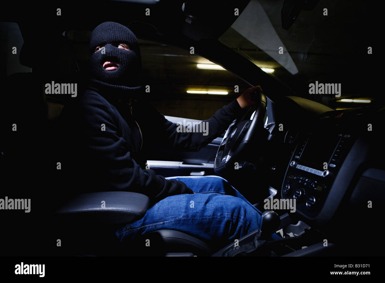 Masked thief sitting in car Stock Photo - Alamy