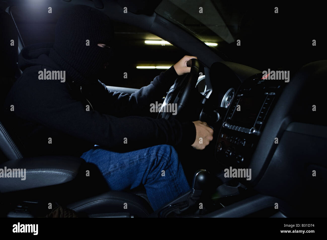 Masked thief sitting in car Stock Photo - Alamy