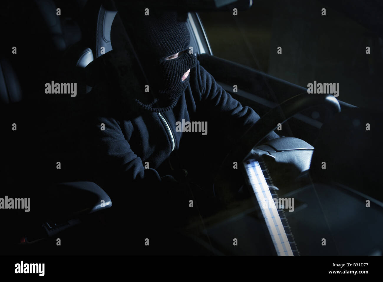 Front profile of masked thief in car Stock Photo - Alamy