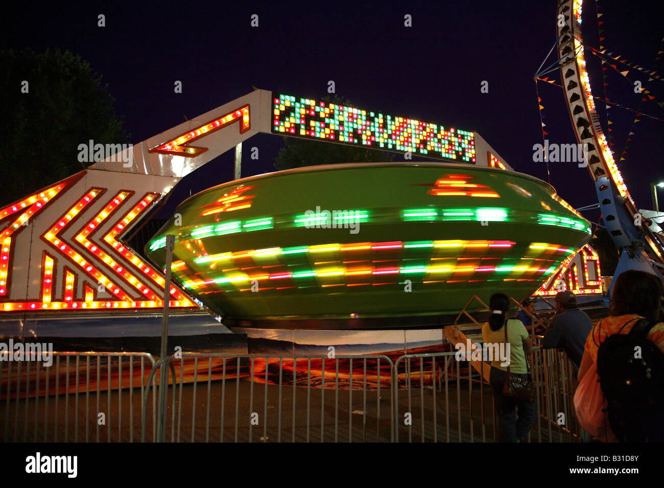 Space ship funfair ride. Large flying saucer shape whorling around with ...