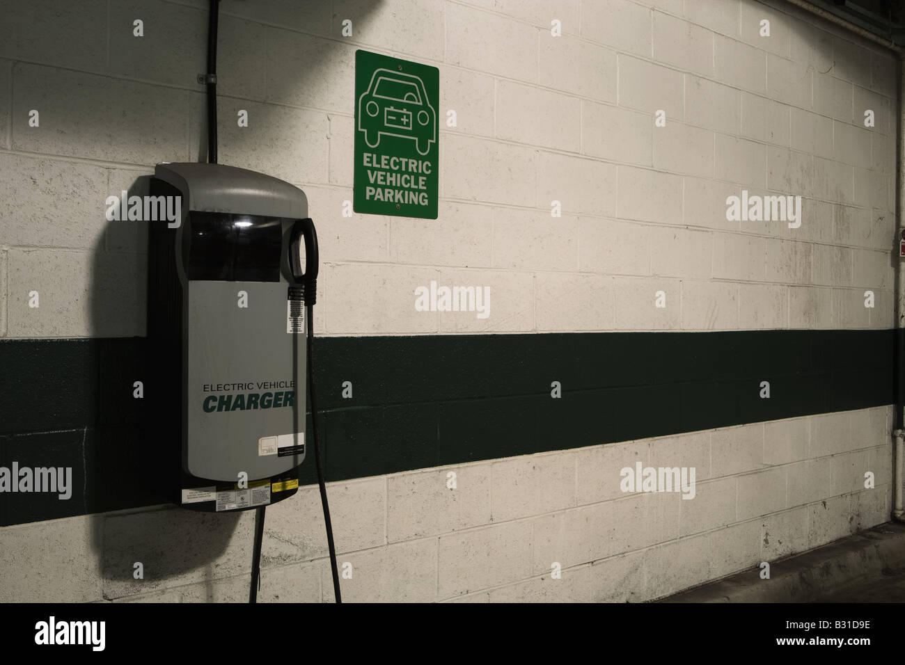 Electric vehicle charger in car park Stock Photo - Alamy