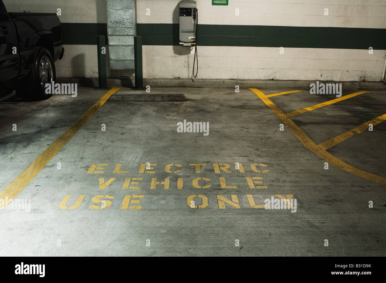 Electric vehicle charger in car park Stock Photo - Alamy
