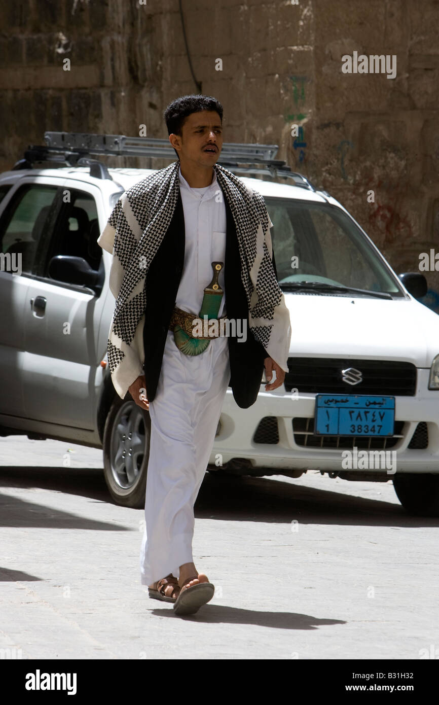A young Muslim man from Yemen walking through Old Sanaa City wearing ...