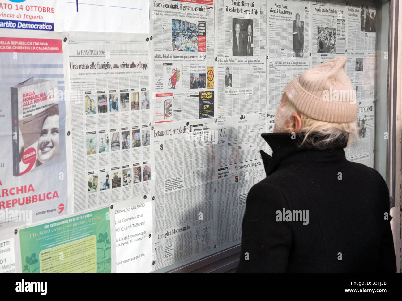Man reading the leftist newspaper L Unita on display outside the ...