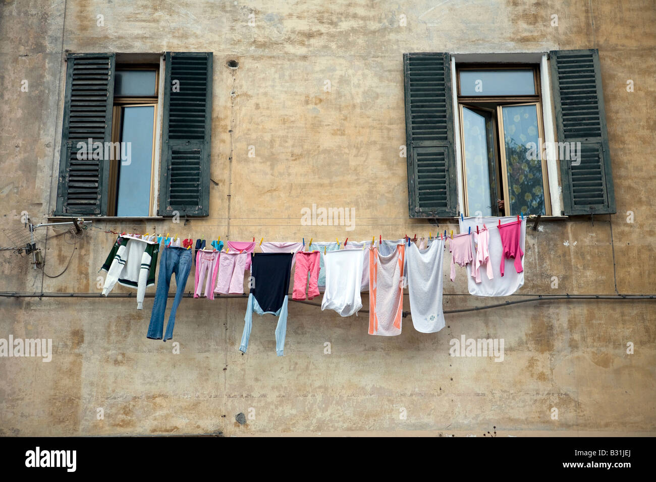 Typical clothesline between windows on the facade of a building in Ventimiglia Stock Photo - Alamy