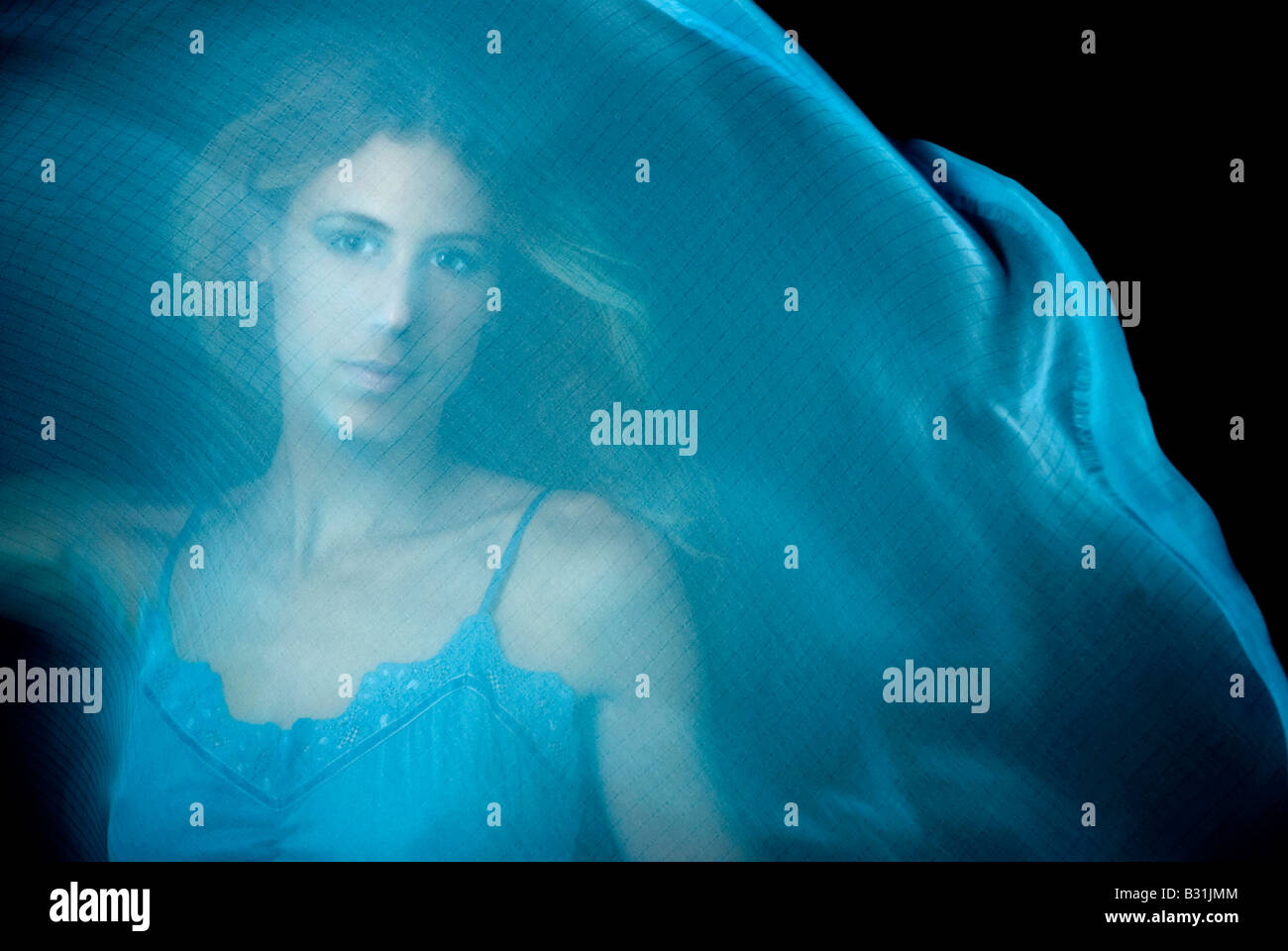 beautiful woman behind blue fabric Stock Photo - Alamy