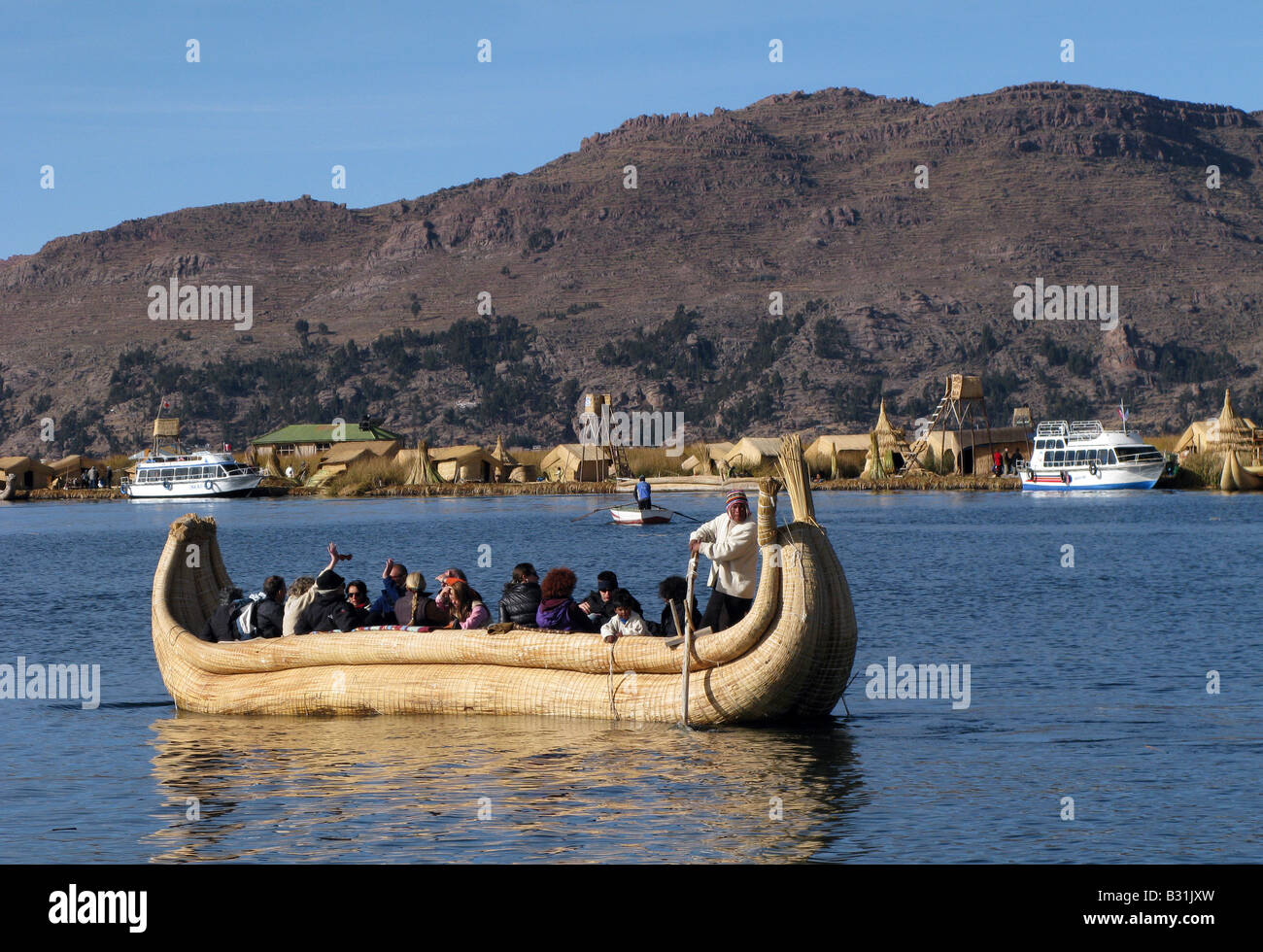 Uros people and tourists on reed boat on self-fashioned floating reed ...