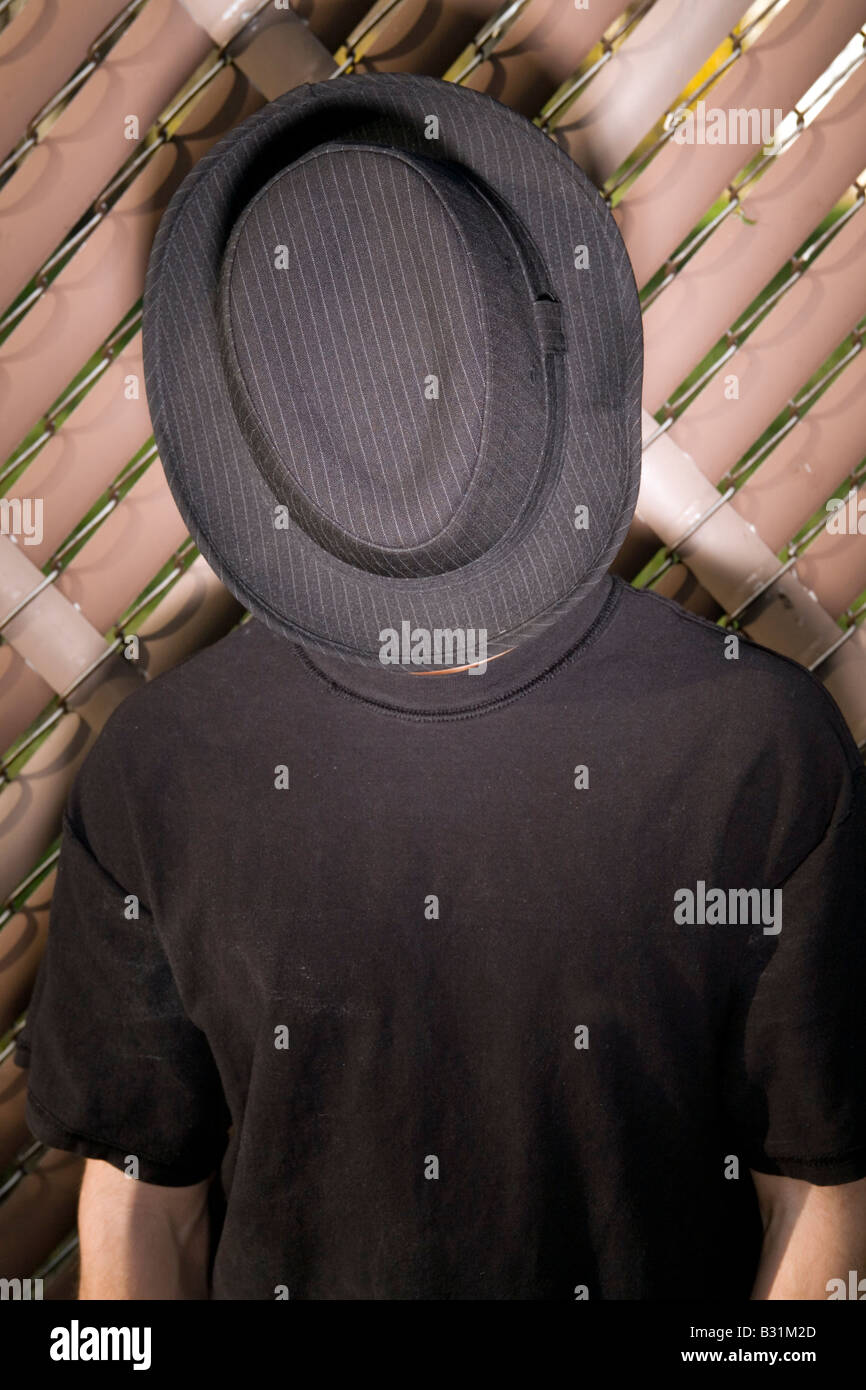 Male Teenage acts cool and poses with hat on face for the camera Stock ...