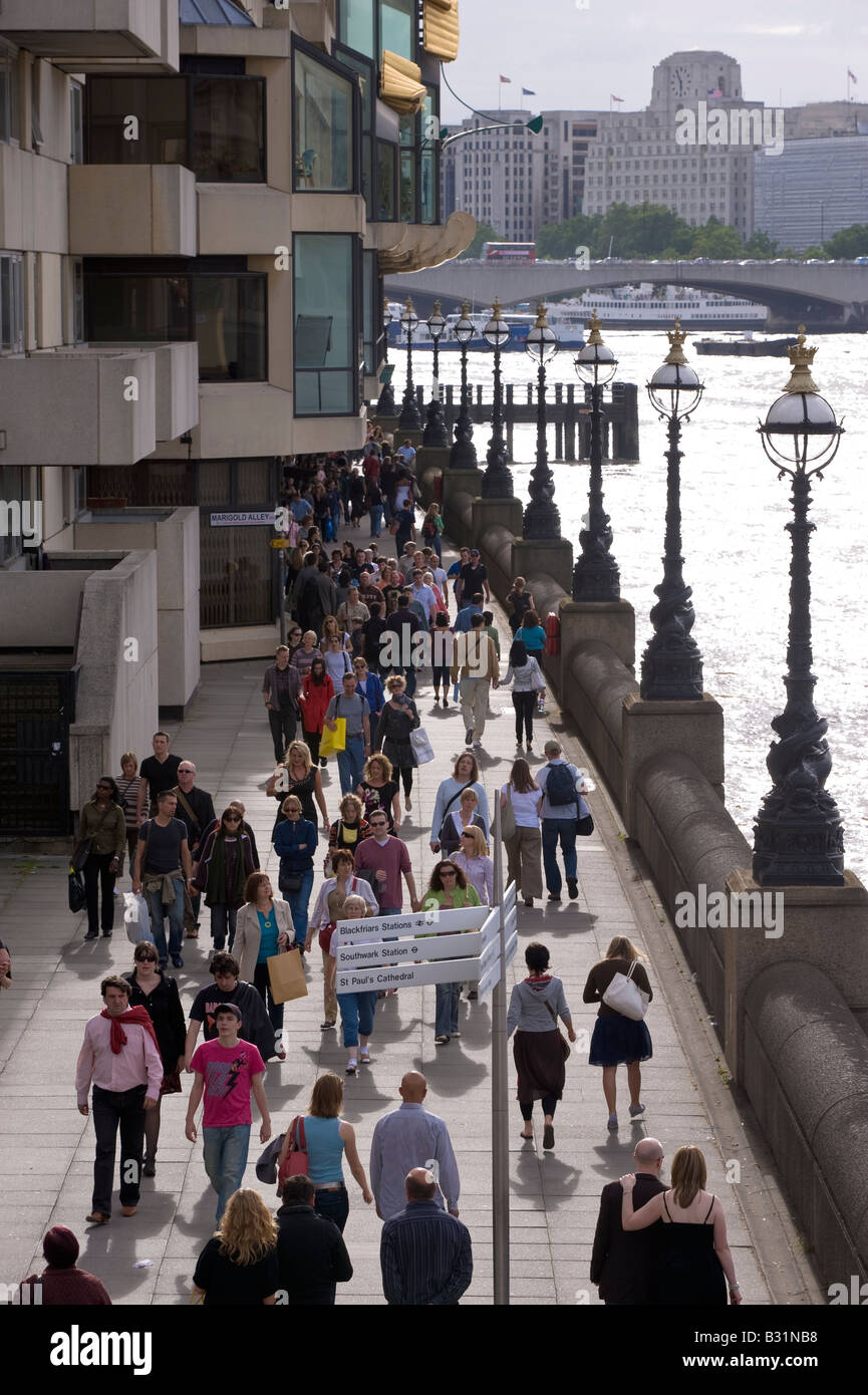pedestrians walking along Queens Walk by Thames River London United ...
