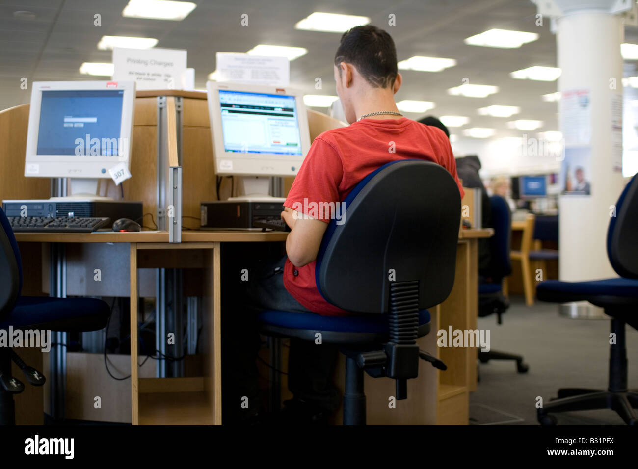A student uses a computer in a public library Stock Photo - Alamy