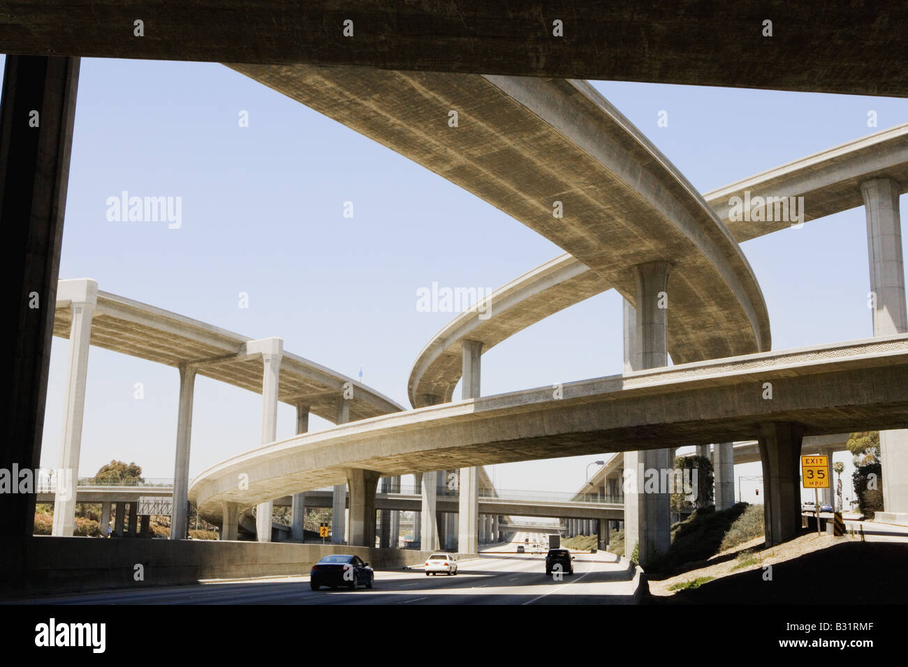 Cars traveling along freeway with elevated interchange above Stock ...