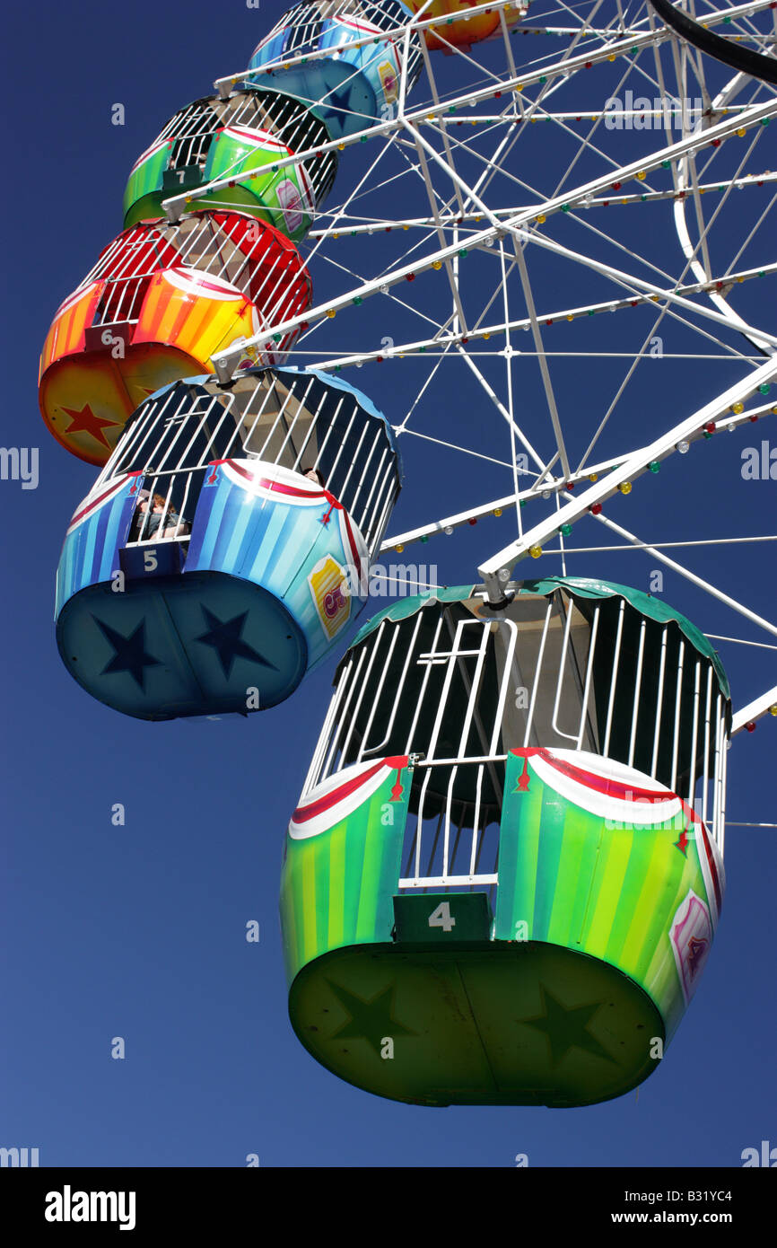 CLOSE UP OF FERRIS WHEEL CARRIAGES AT FAIRGROUND AGAINST BRIGHT BLUE ...