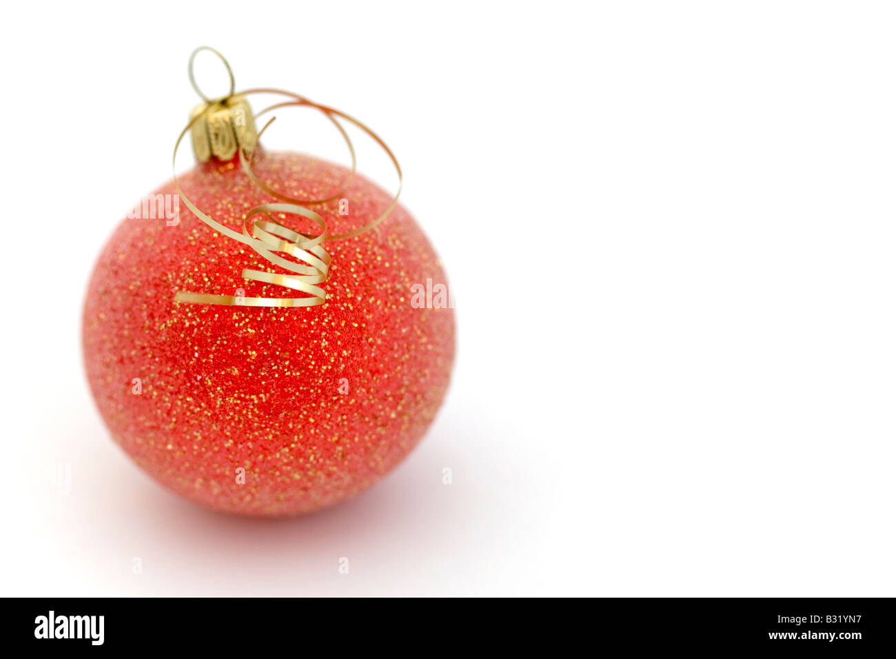 Single red frosted bauble with gold ribbon on a white background Stock ...